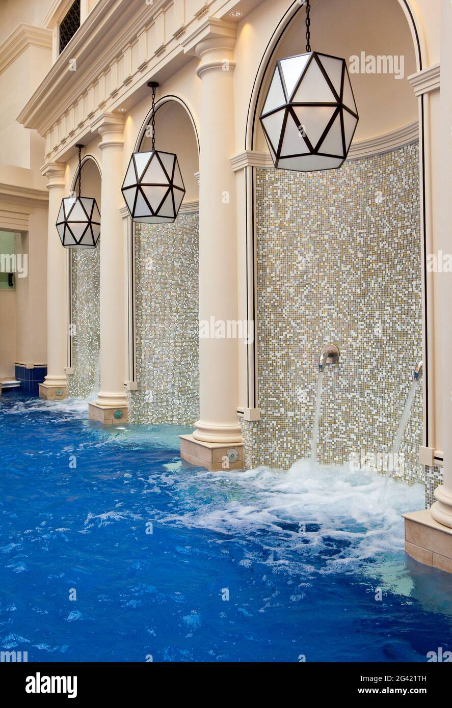 Spouts of water cascading into an interior pool decorated with mosaics ...