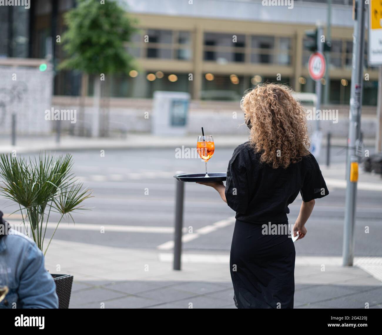 a masked waitress carries a cocktail on a tray in a newly opened bar in ...