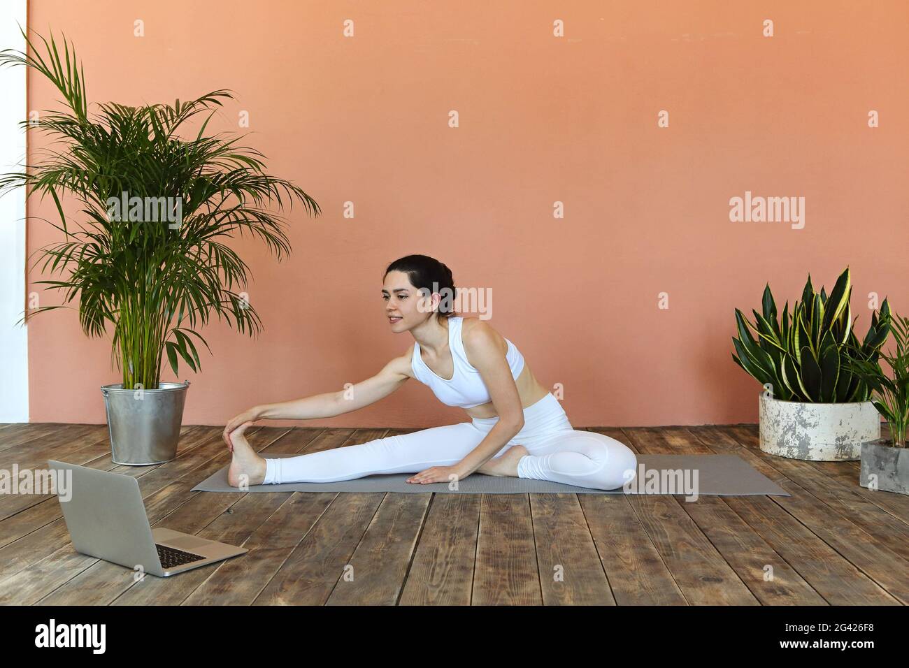 Young woman having online yoga session at home Stock Photo - Alamy