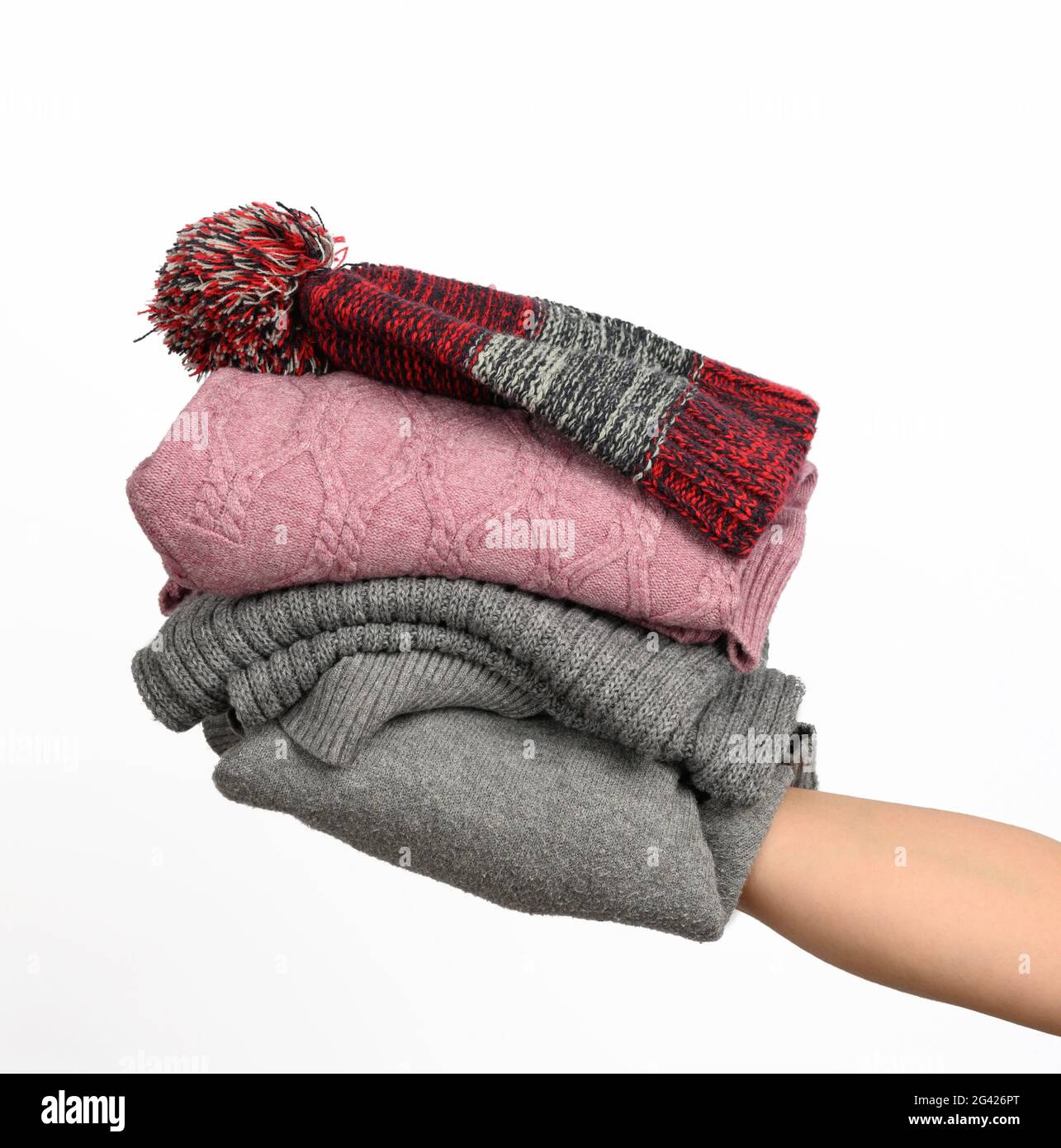 Female hand holding a stack of clothes, help and volunteering concept ...