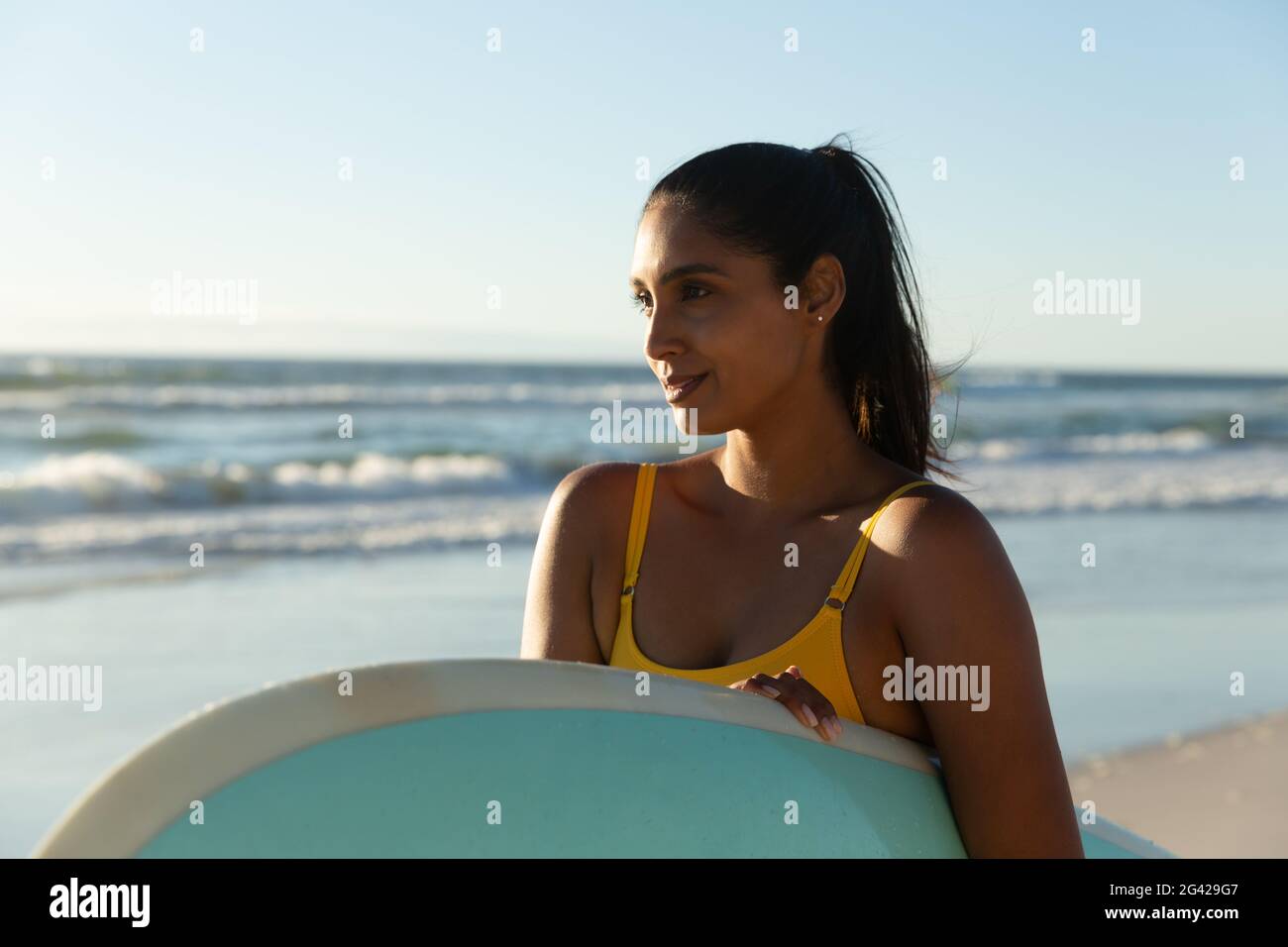 Happy woman carrying surfboard hi-res stock photography and images - Alamy