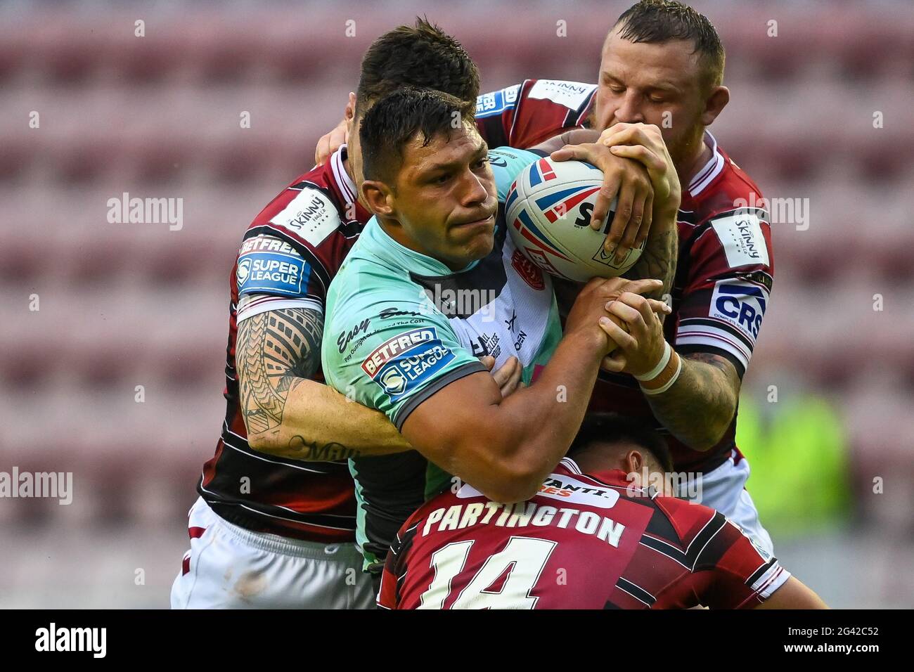 Wigan, UK. 18th June, 2021. Ryan Hall (5) of Hull KR is tackled by John ...
