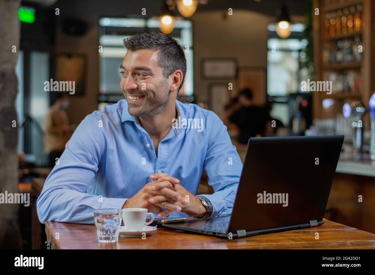 Smiling man sitting table using hi-res stock photography and images - Alamy