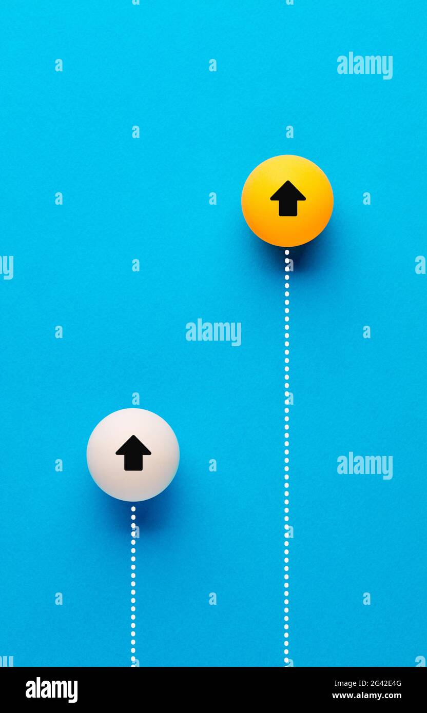 White and orange table tennis balls are racing with each other on blue ...