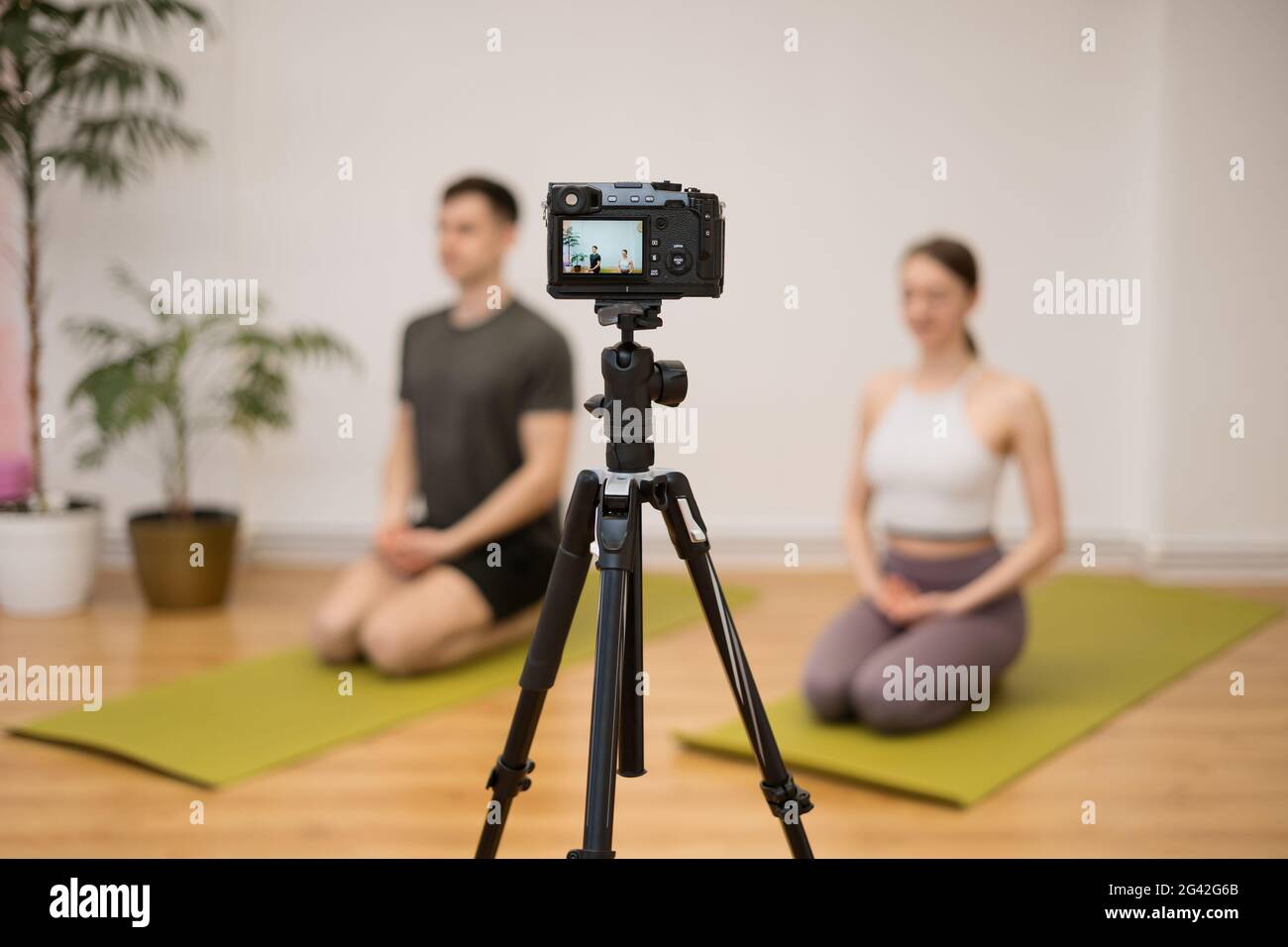 Yoga trainer teaching online training program in home studio behind ...