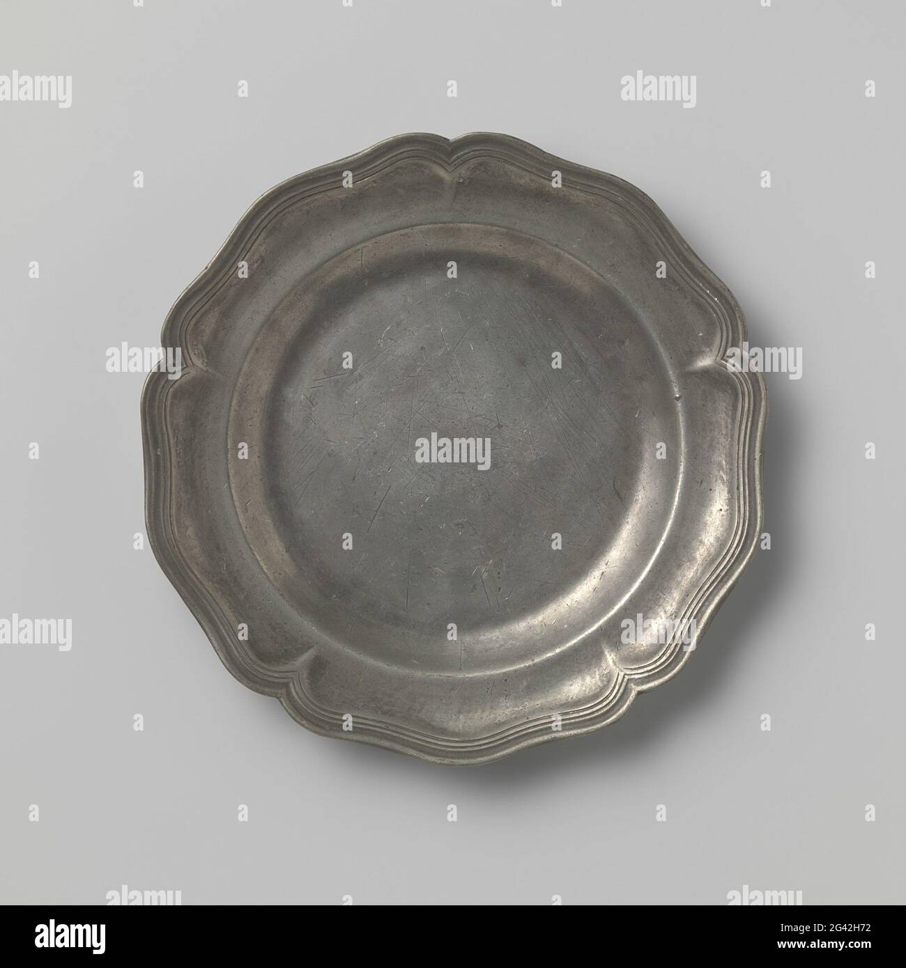 Plate of tin with scalloped edge. Plate of tin. The scalloped edge is ...