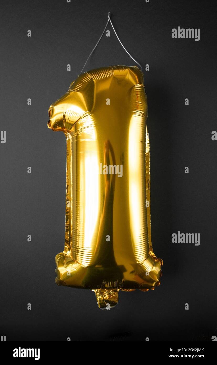 Gold foil Balloon number one isolated on black Stock Photo - Alamy