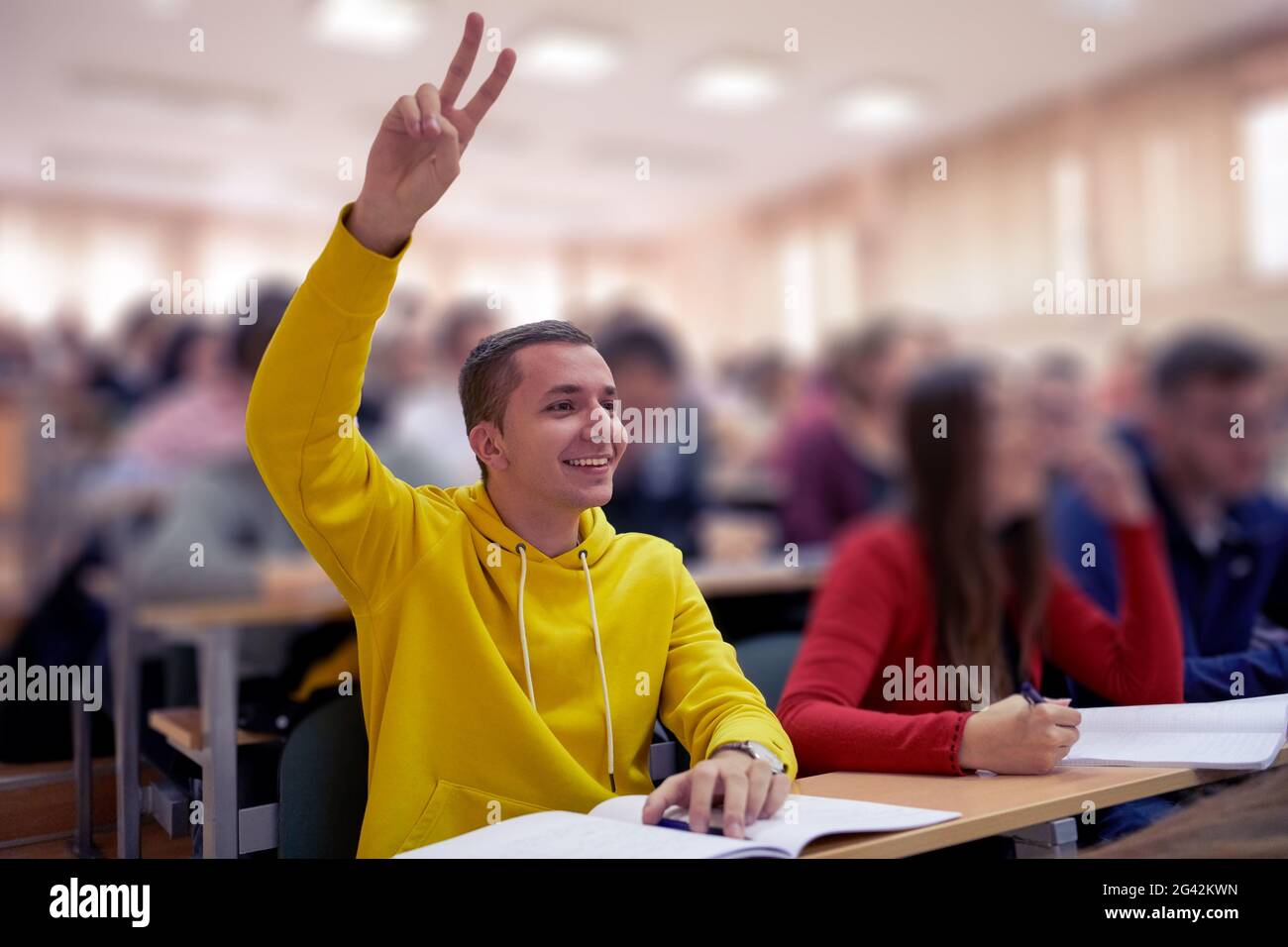 The student raises his hands asking a question in class in college ...