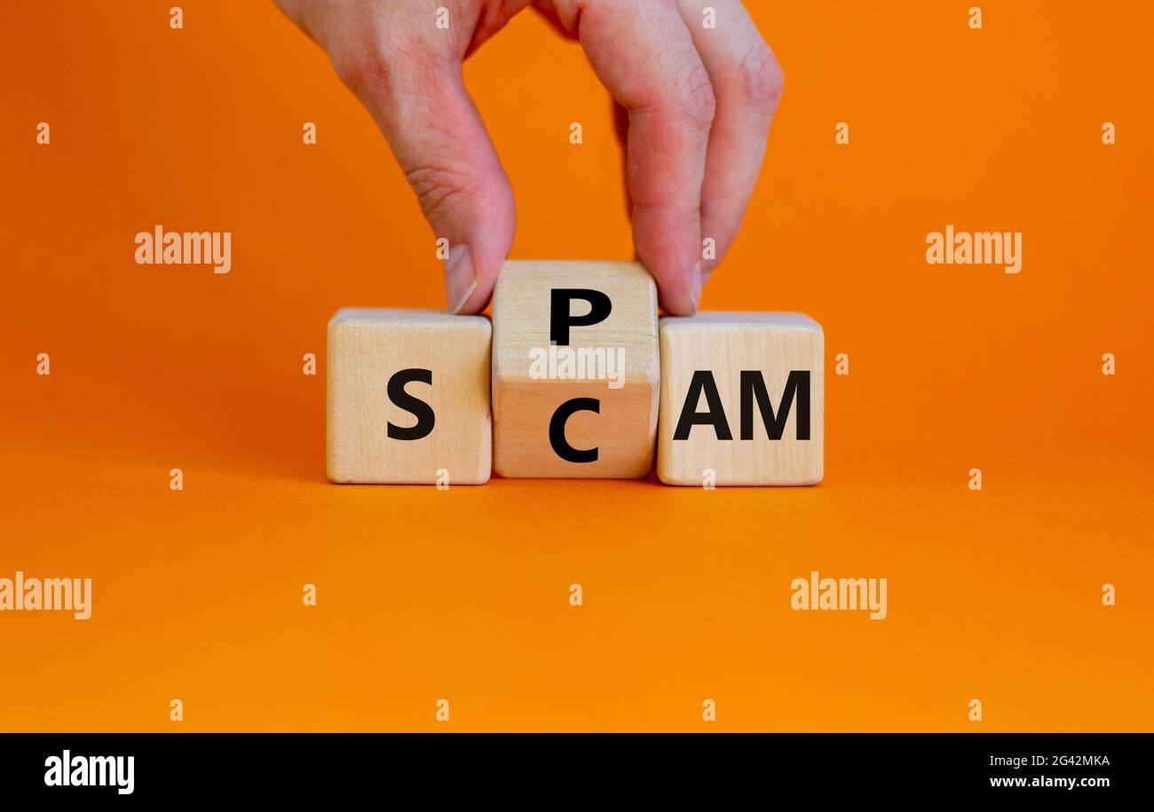 Spam and scam symbol. Businessman turns the wooden cube and changes the ...