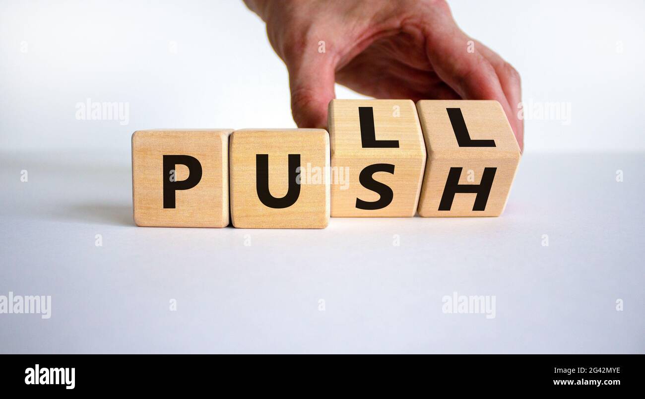 Pull or push symbol. Businessman turns wooden cubes and changes the ...