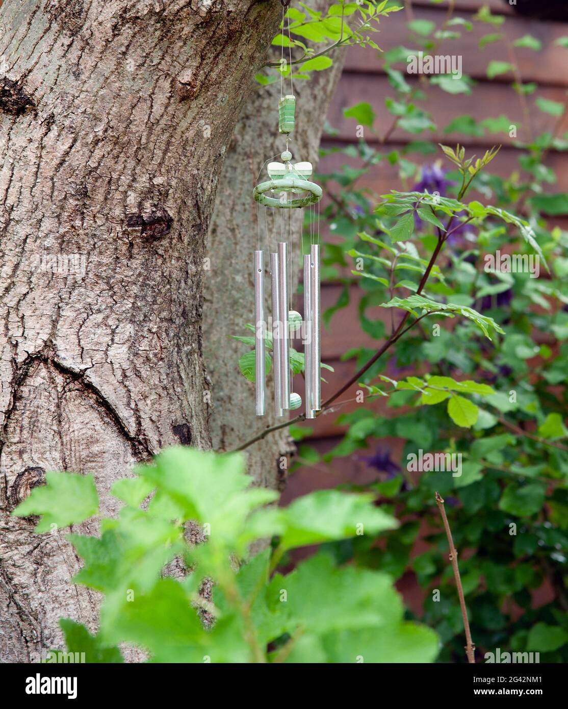 Interesting metal wind chimes hanging in garden Stock Photo - Alamy