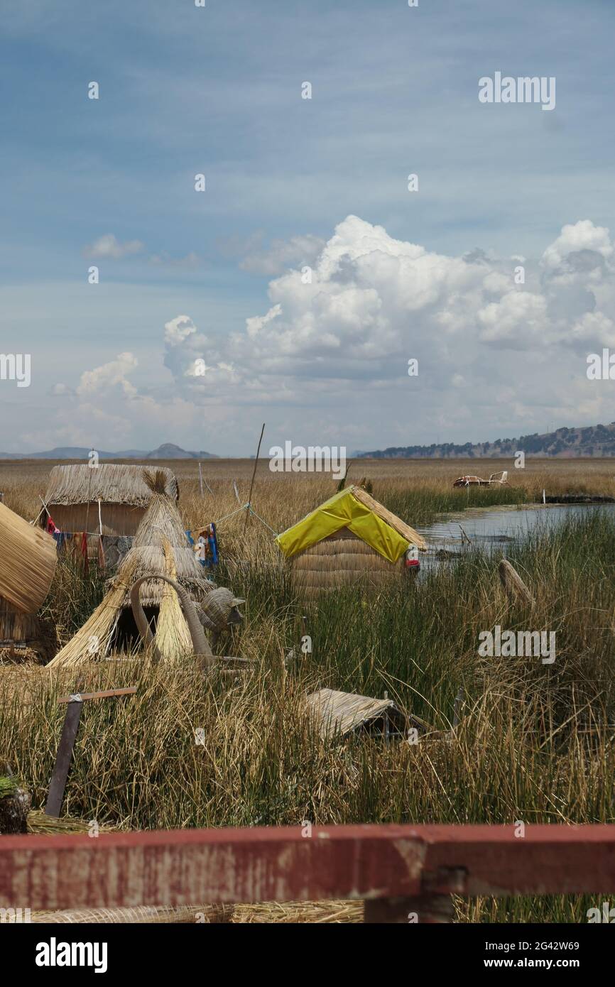Lake Titicaca Peru village buildings straw hut huts clouds low sky view ...