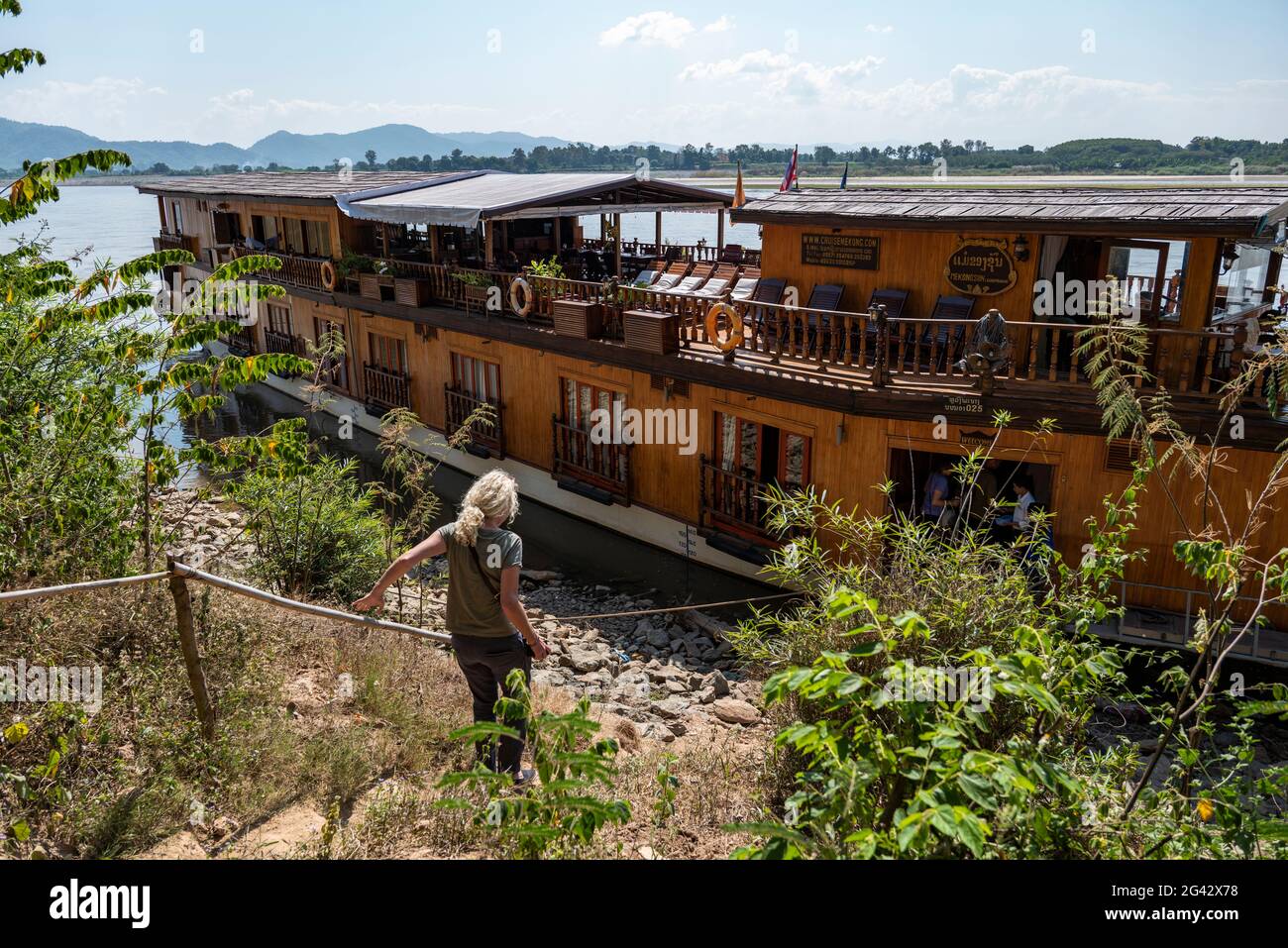 Woman descends to river cruise ship Mekong Sun on Mekong River, Houayxay (Huay Xai), Bokeo ...