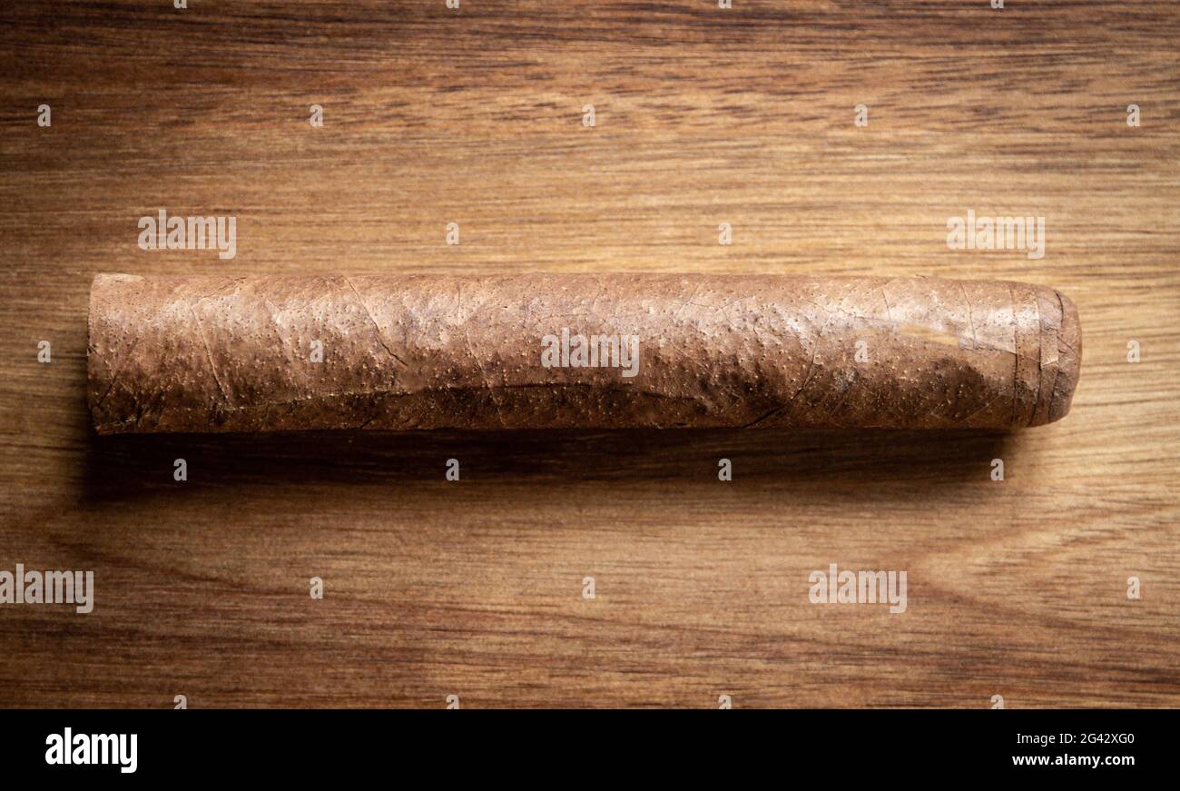 Brown cuban cigar on wooden background Stock Photo - Alamy