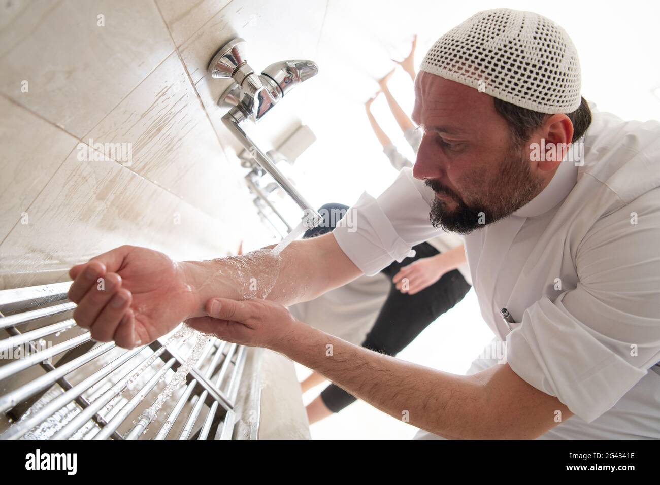 A group of Muslims take ablution for prayer. Islamic religious rite ...