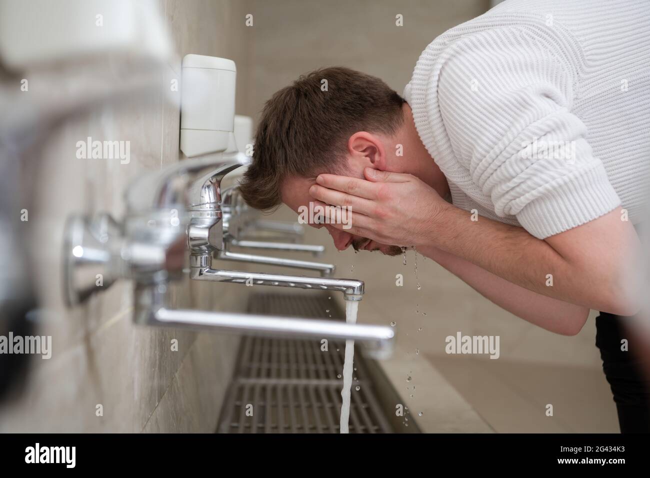 A Muslim takes ablution for prayer. Islamic religious rite Stock Photo ...