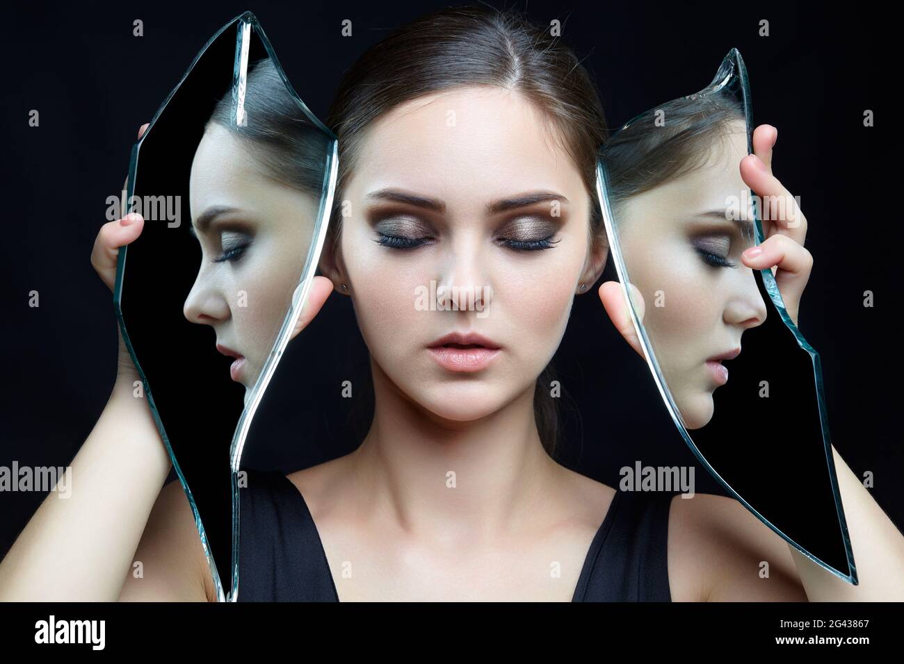 Young female with eyes closed and mirror shard in hands Stock Photo - Alamy