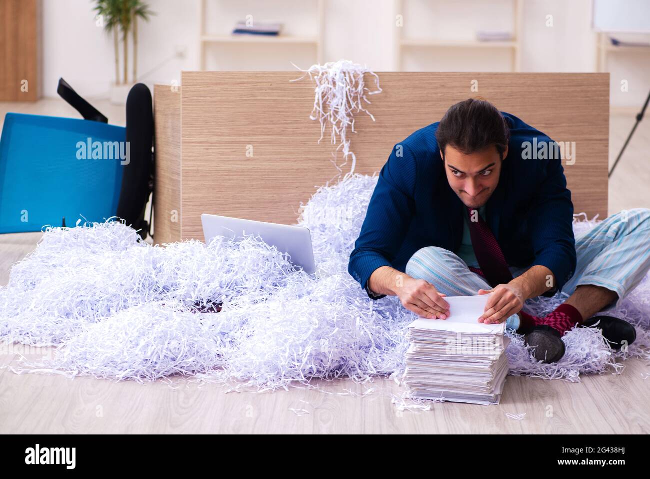 Young male employee and a lot of cut papers in the office Stock Photo ...