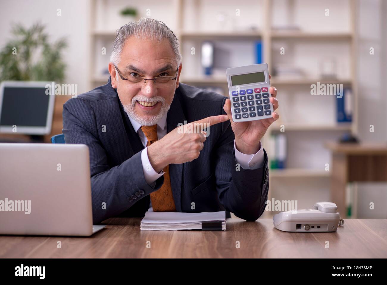 Old male bookkeeper working in the office Stock Photo - Alamy