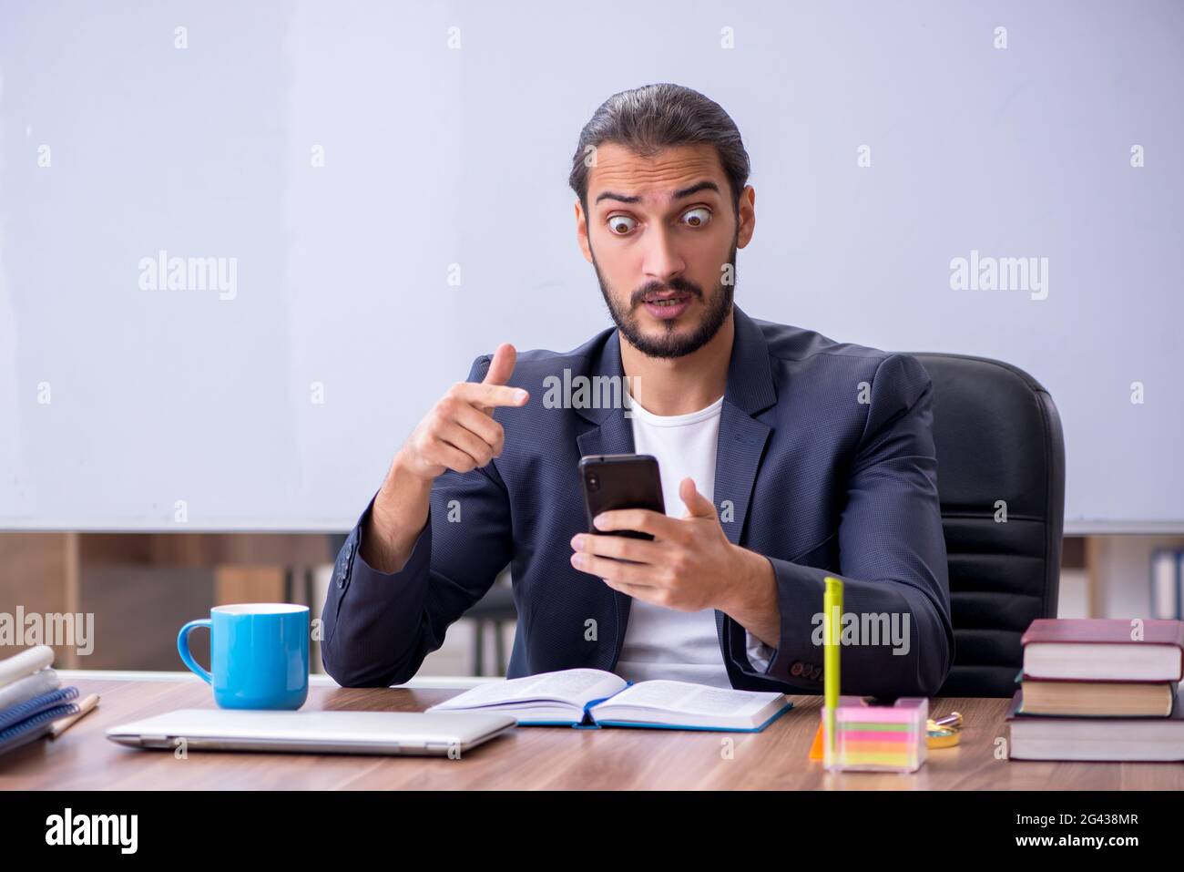 Young male teacher in the classroom Stock Photo - Alamy