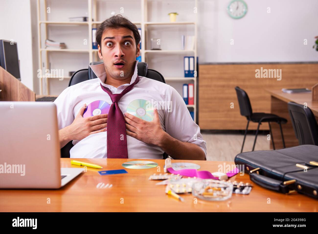 Young drug addicted male employee working in the office Stock Photo - Alamy