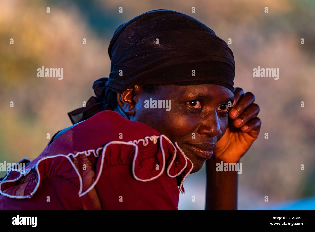 Portrait of a thoughtful looking Rwandan woman in late afternoon light ...