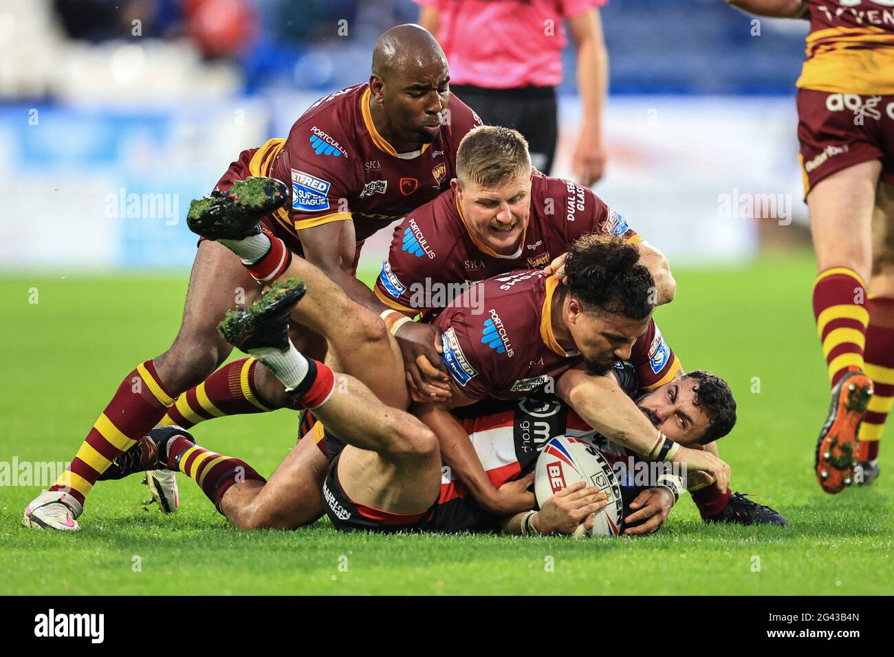 Rhys Williams (22) of Salford Red Devils is tackled by Ashton Golding ...
