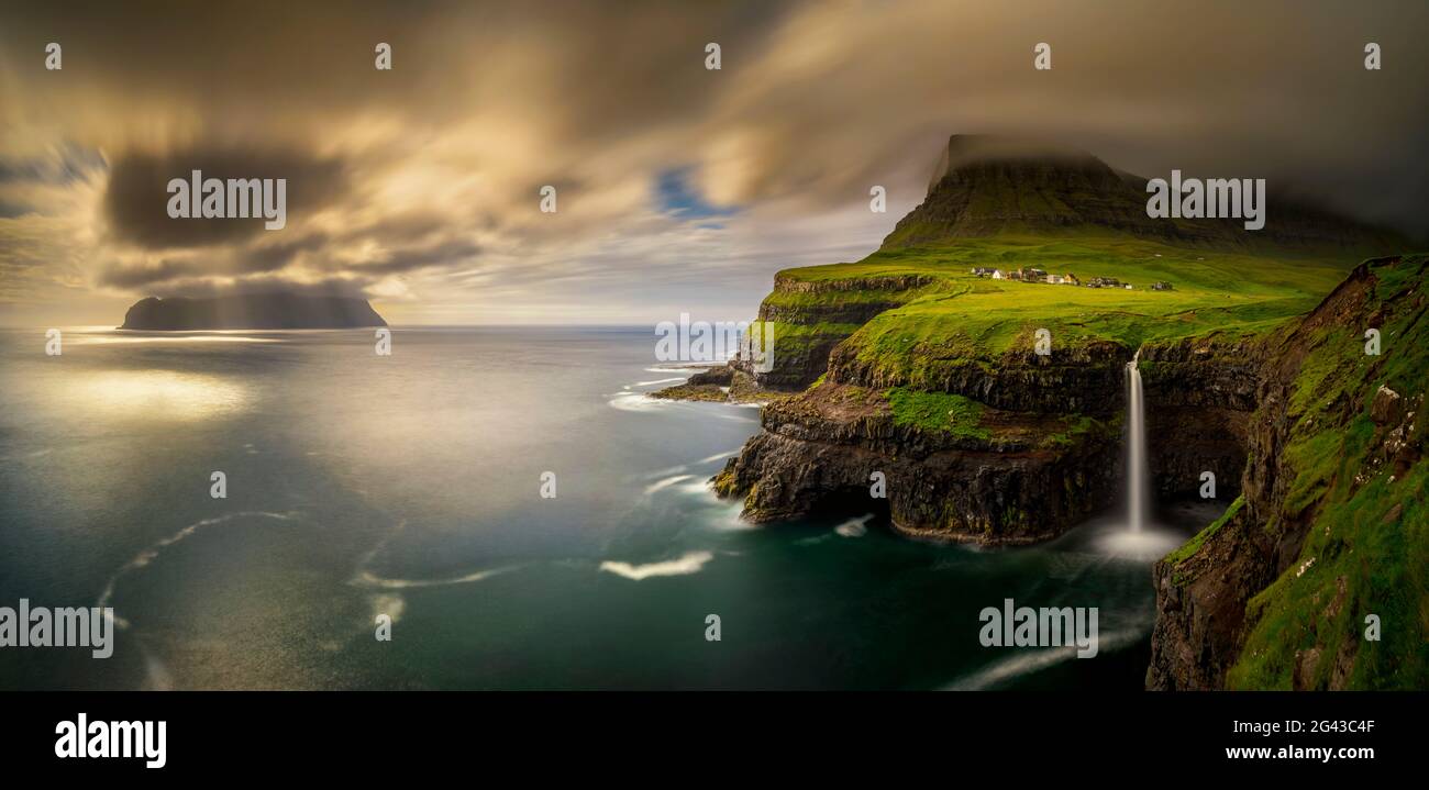 Landscape with coastal cliffs, Mykines island and Gasaldur village at ...