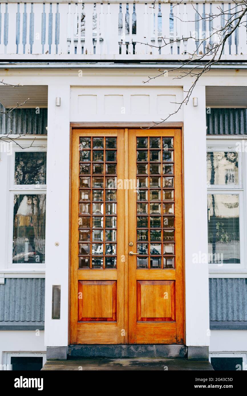 Wooden doors with blown glass in the building with white finishes and ...