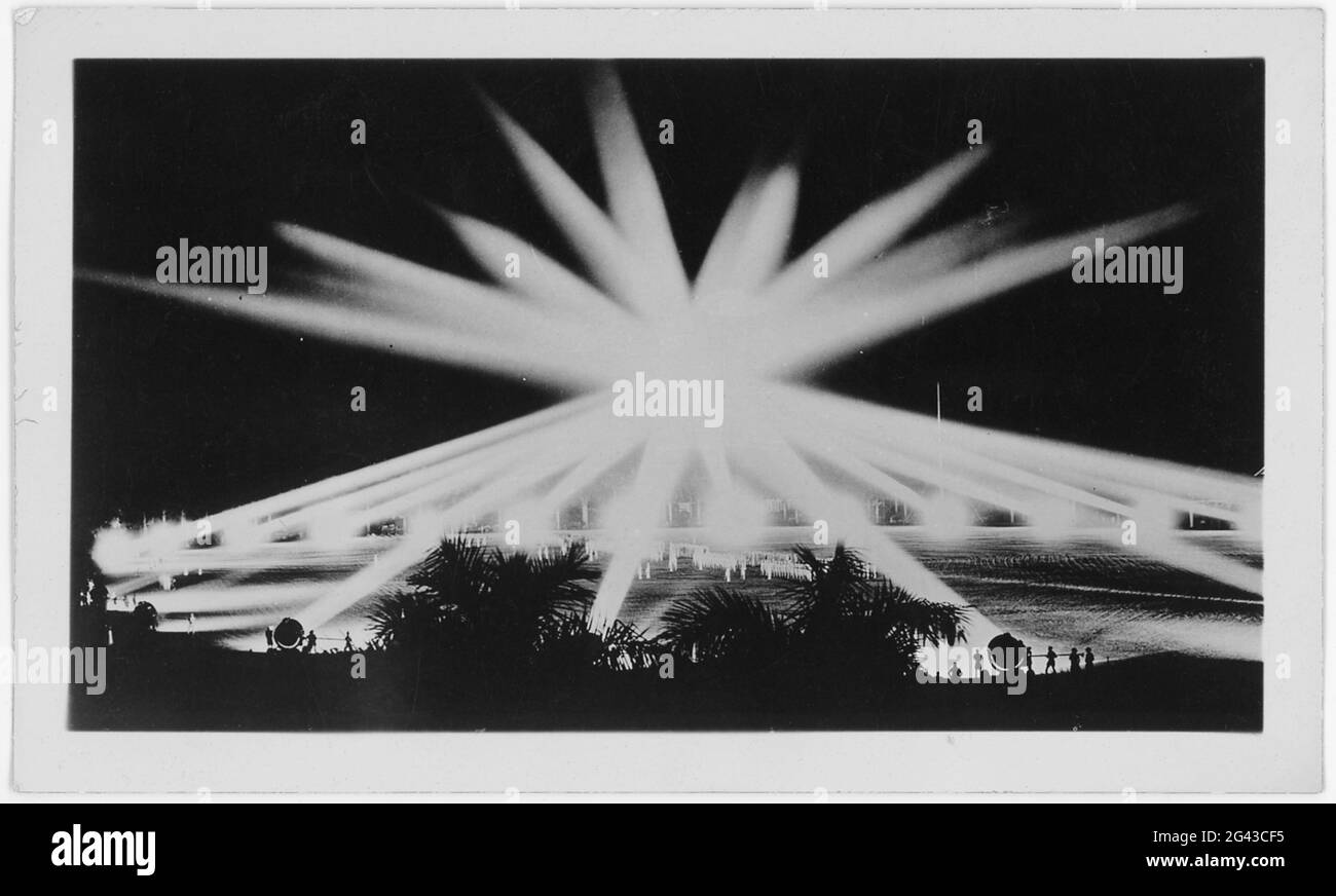 U. S. Army Searchlights Converge in a Cone of Light over a formation of ...