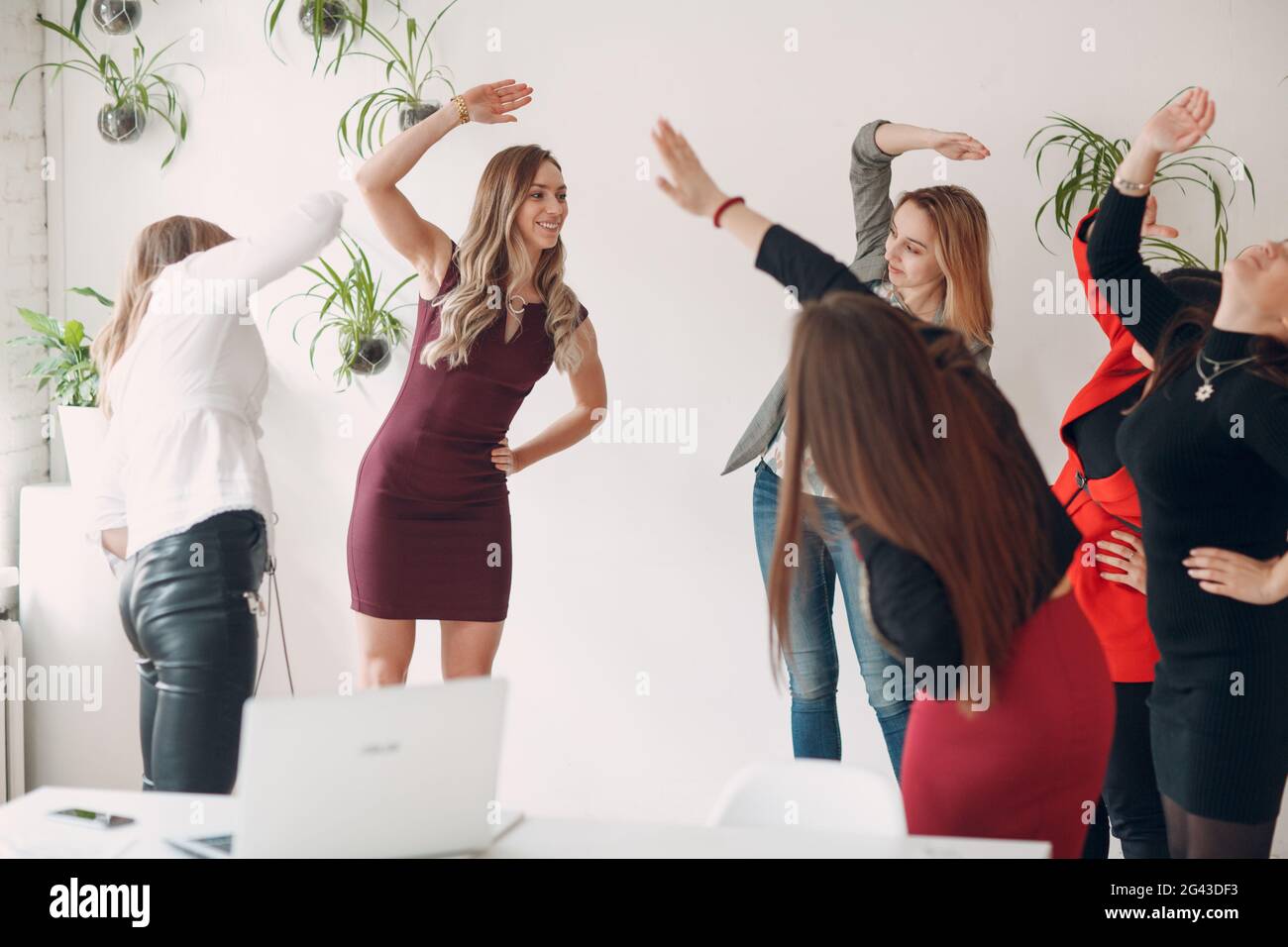 Team women doing exercises in office. Exercising females at work ...