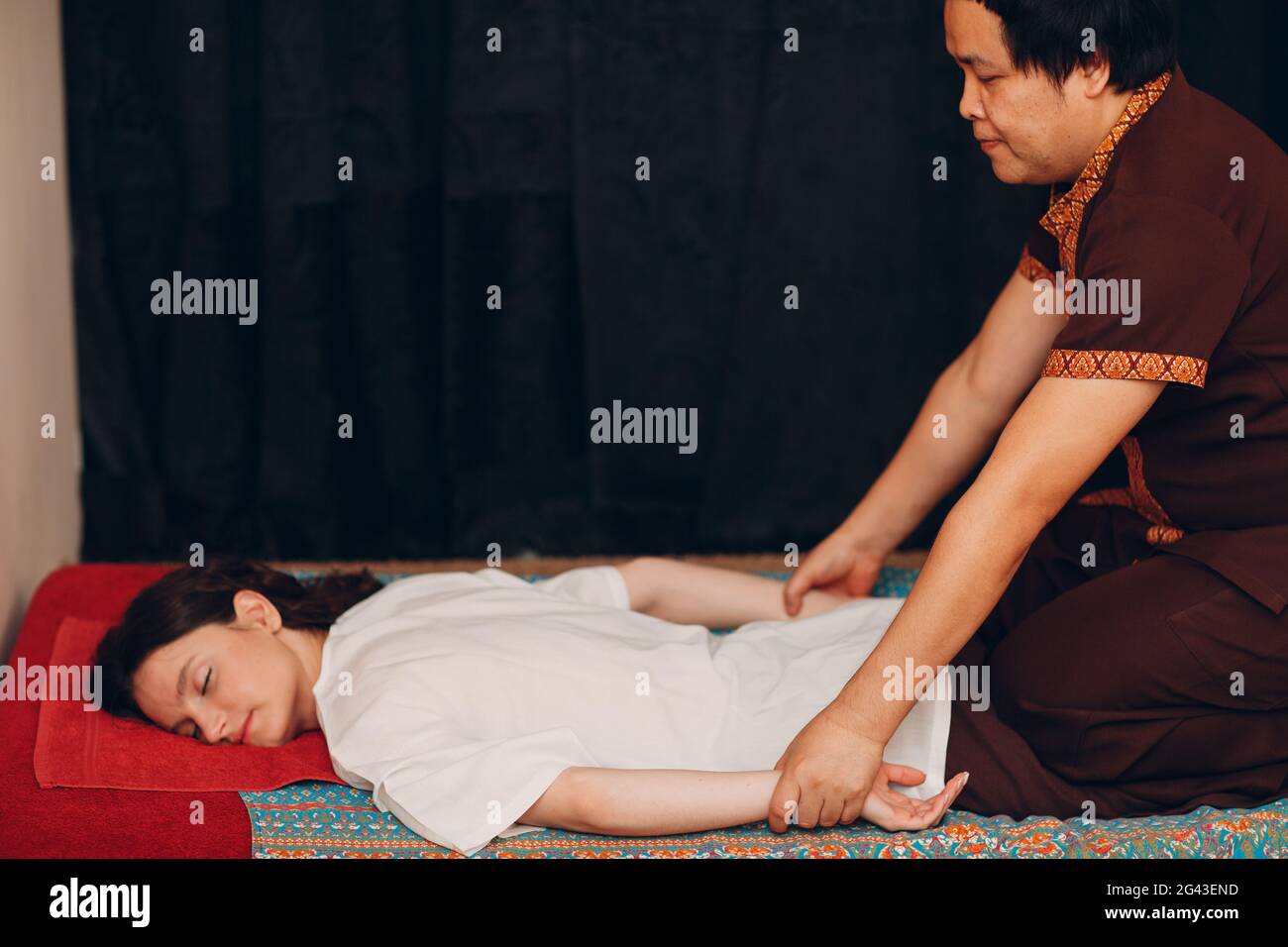 Thai man making classical thai massage procedure to young woman at ...