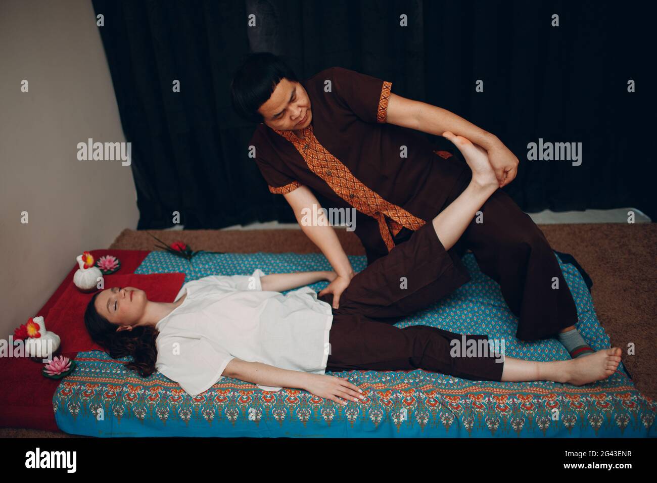 Thai man making classical thai massage procedure to young woman at ...