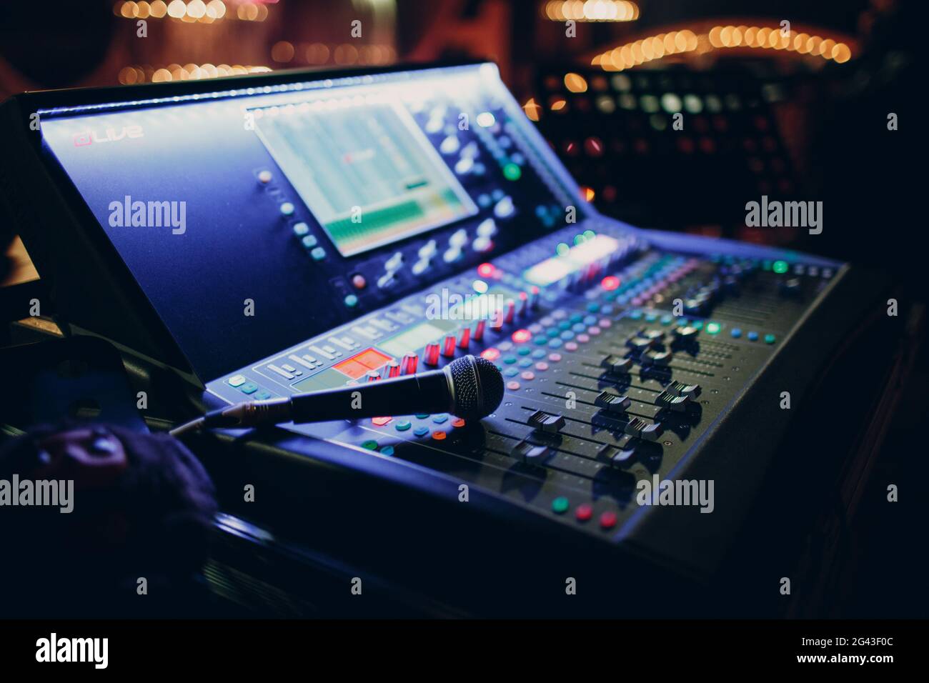 Mixing console and microphone, hand equalizing audio sound channels in ...
