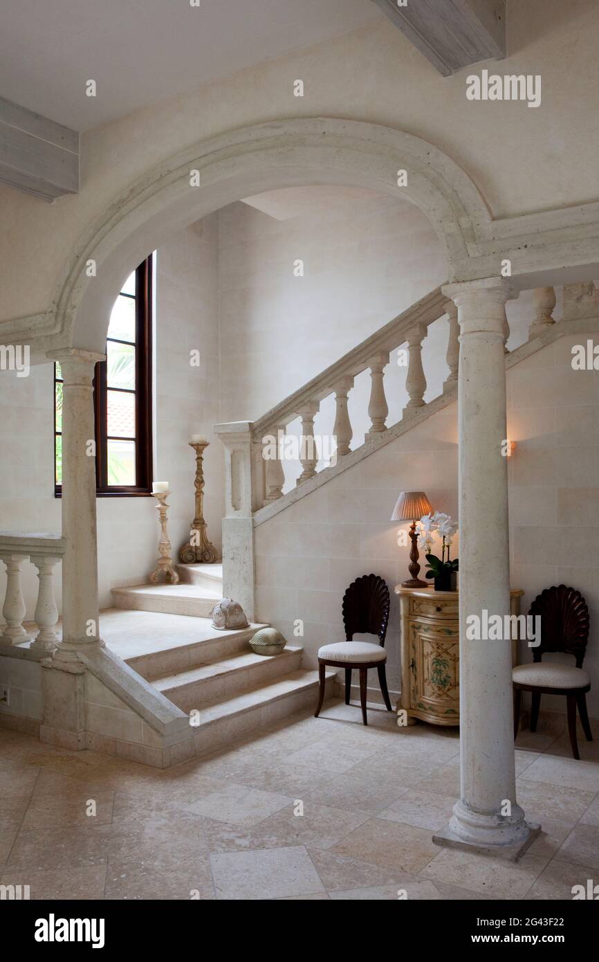 Interior shot of a white, sandstone hallway of a colonial style home in ...