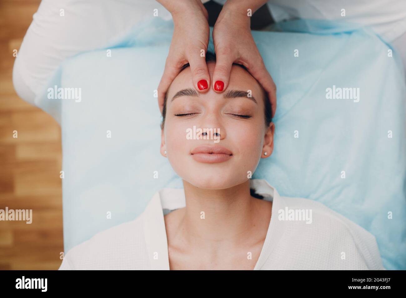 Beautiful Young Woman Getting Face Treatment Massage At Beauty Spa
