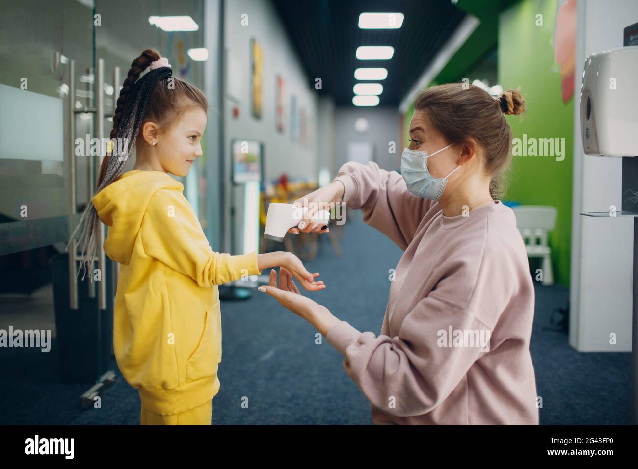 Child hand temperature measurement by laser thermometer at kindergarten ...