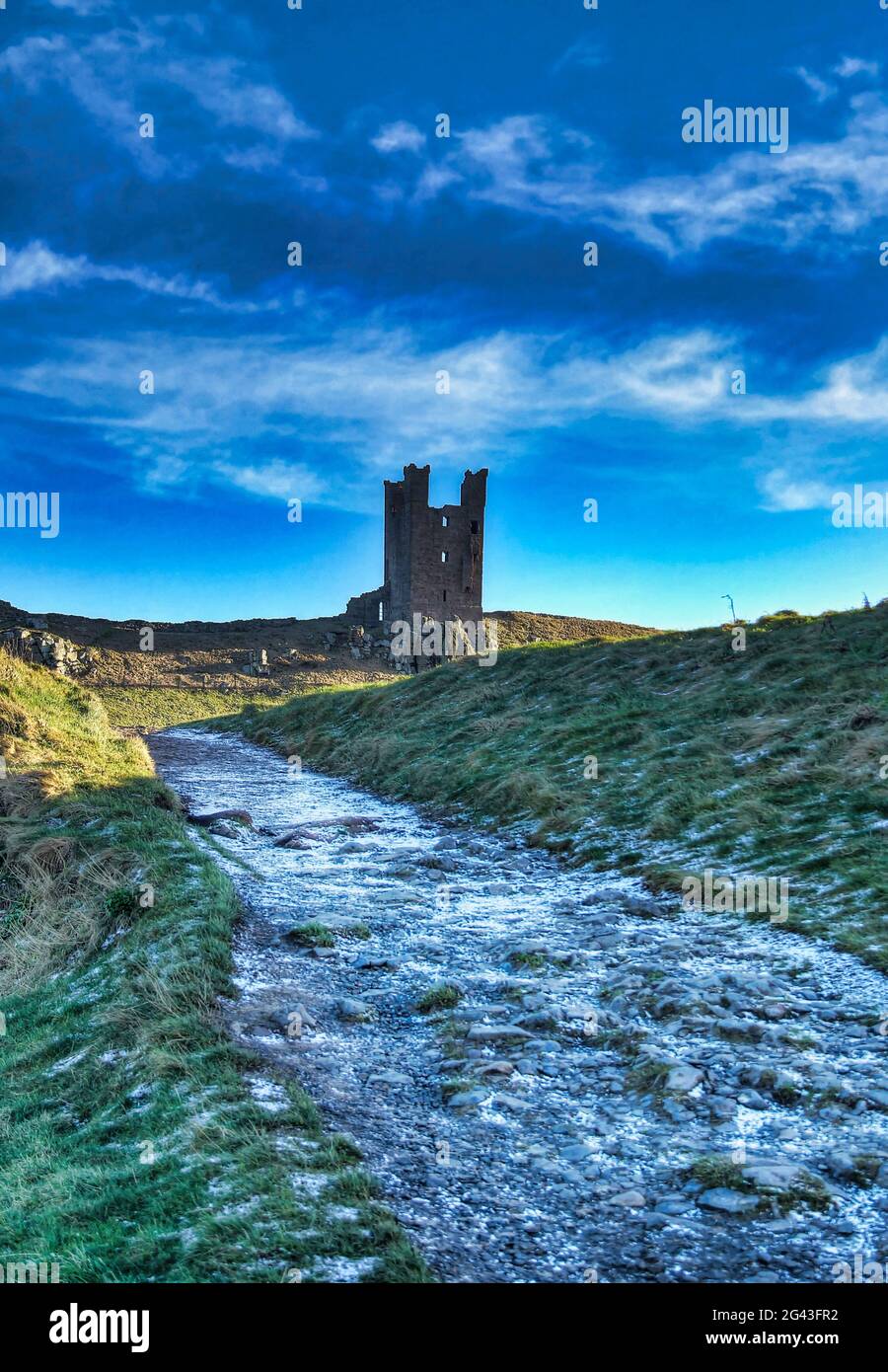 Icy pathway leading to Dunstanburgh Castle, Northumberland Stock Photo ...