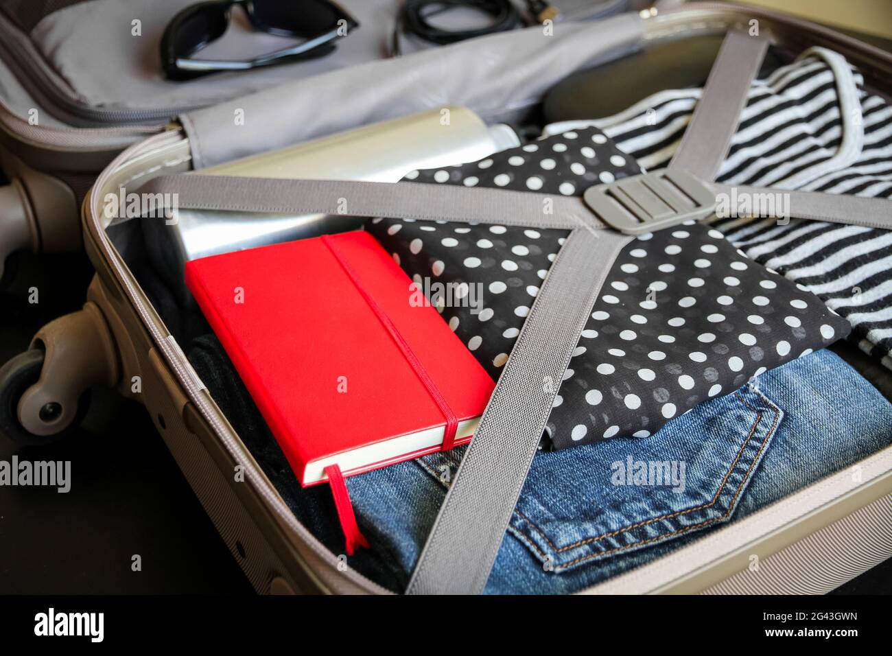 Open suitcase full of clothes isolated on black background Stock Photo ...