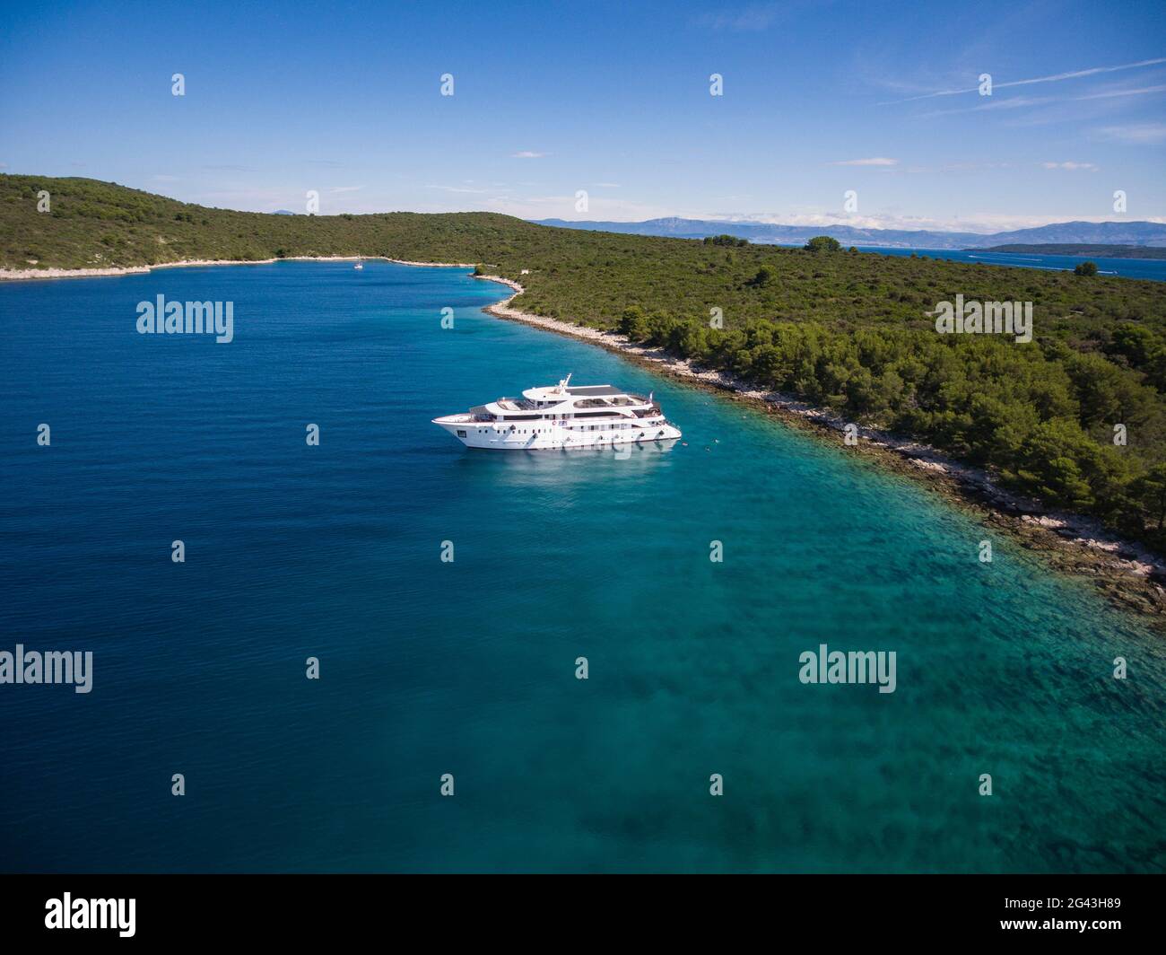 Aerial view of cruise ship in pristine bay at a swim stop for ...