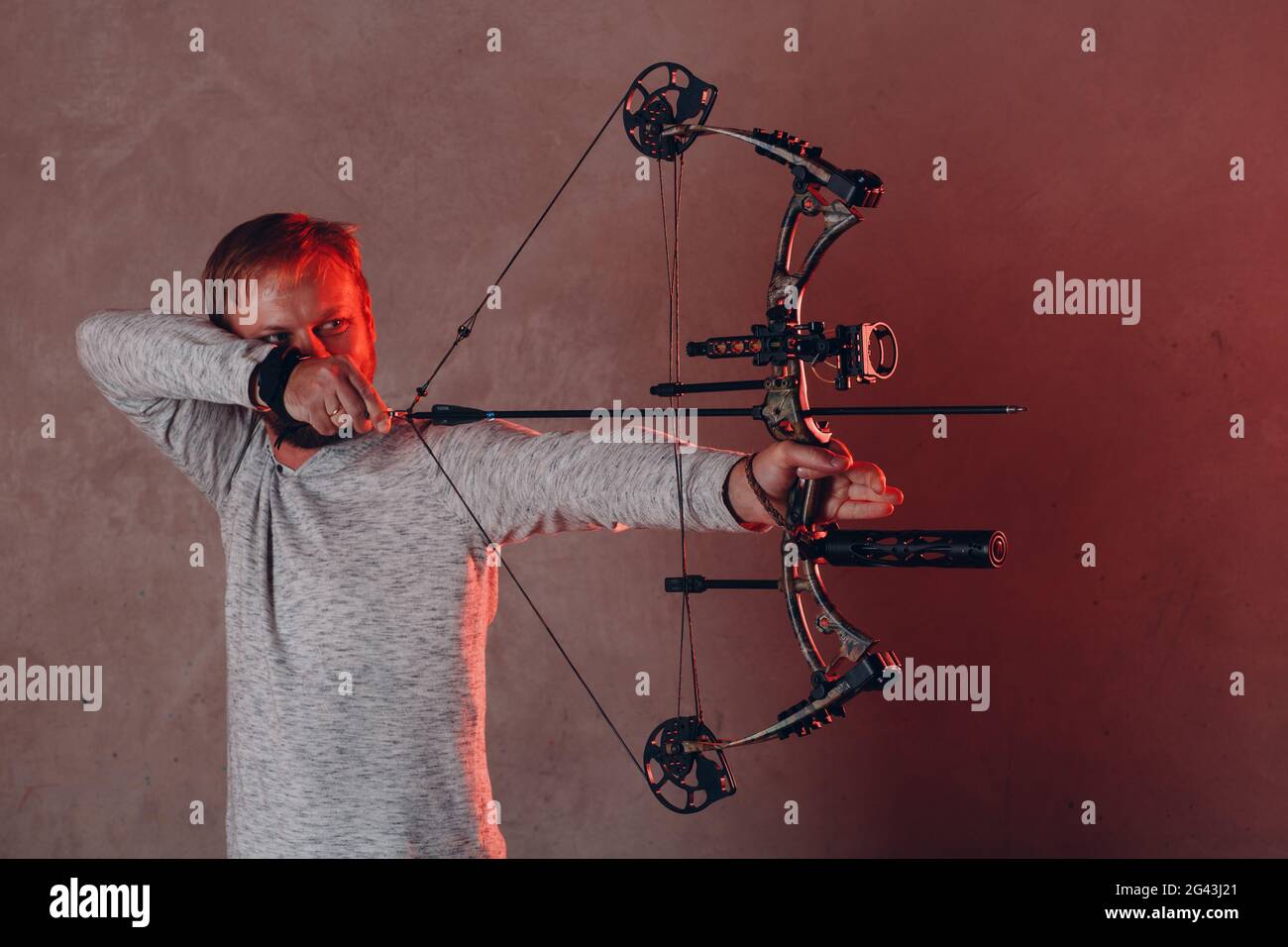 Archer man with modern block sport bow and arrow Stock Photo - Alamy