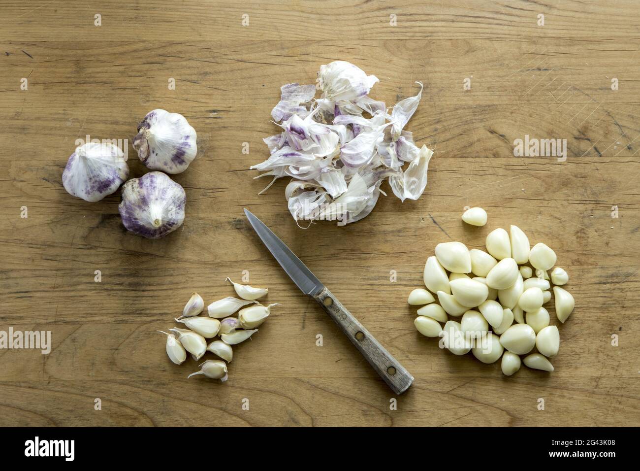 Garlic and a knife on a cutting board Stock Photo - Alamy