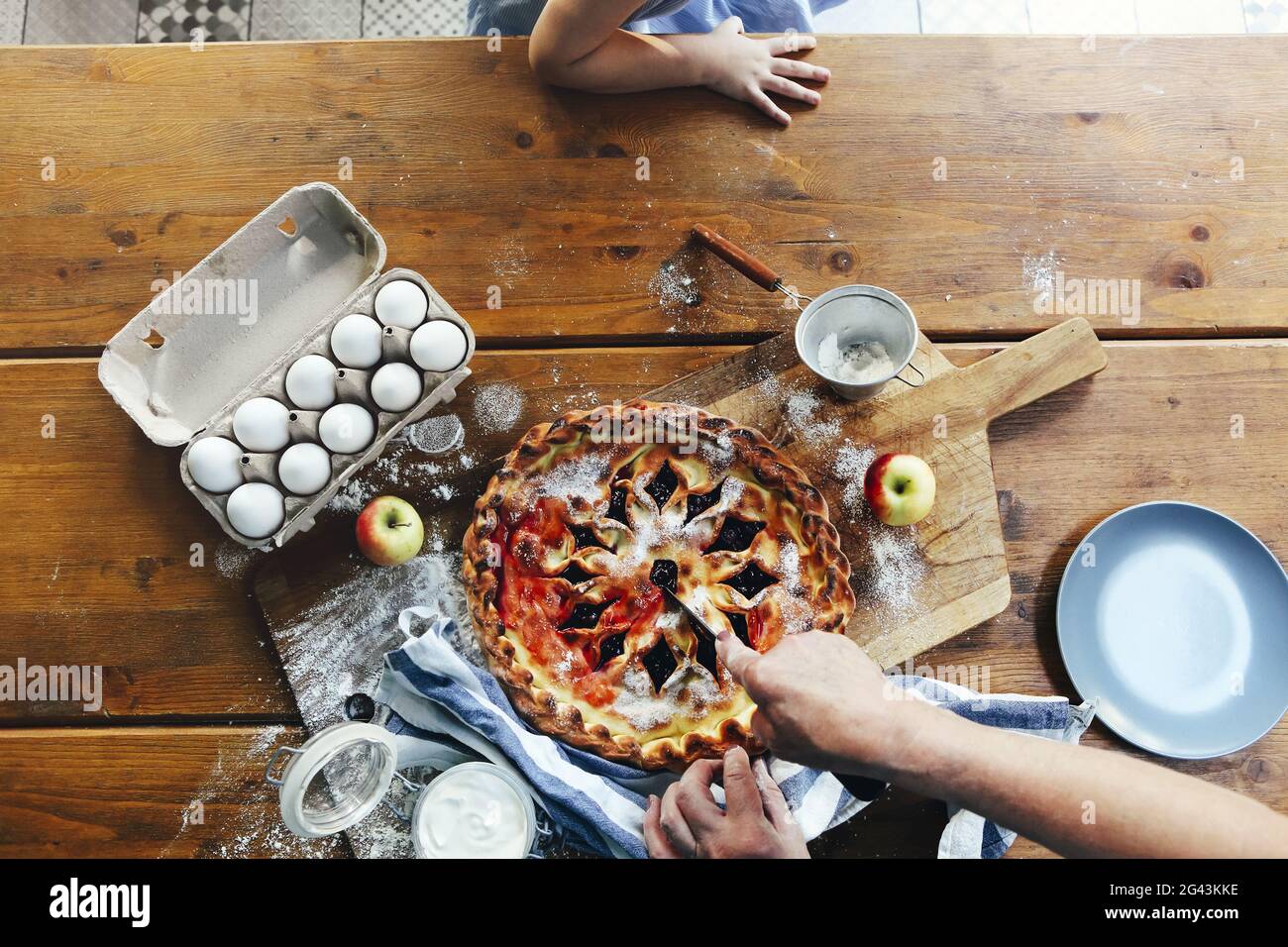 Crop person cutting pie on table Stock Photo - Alamy