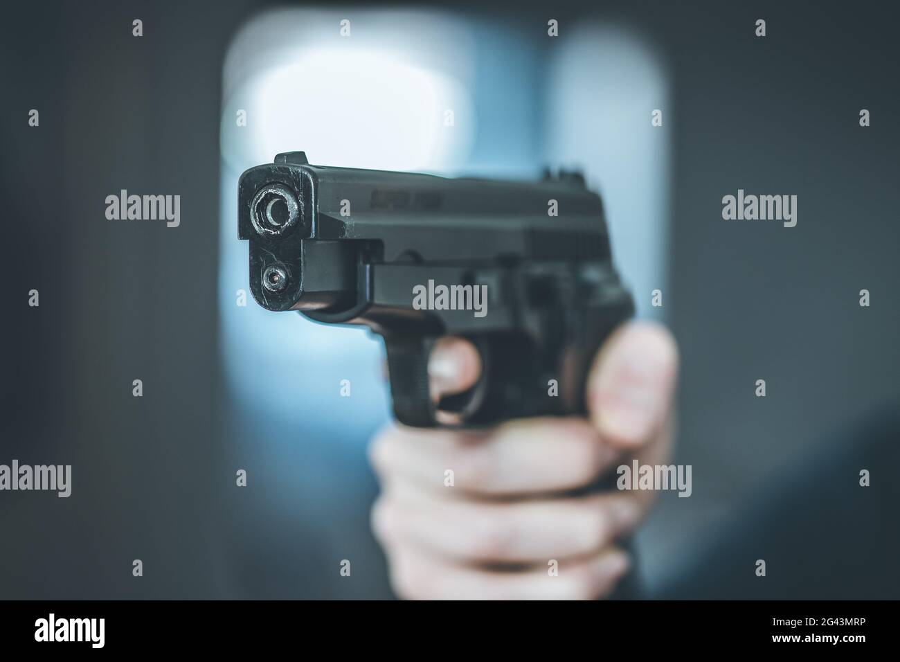 Crime or robbery concept: Man with black gun is aiming with his weapon ...