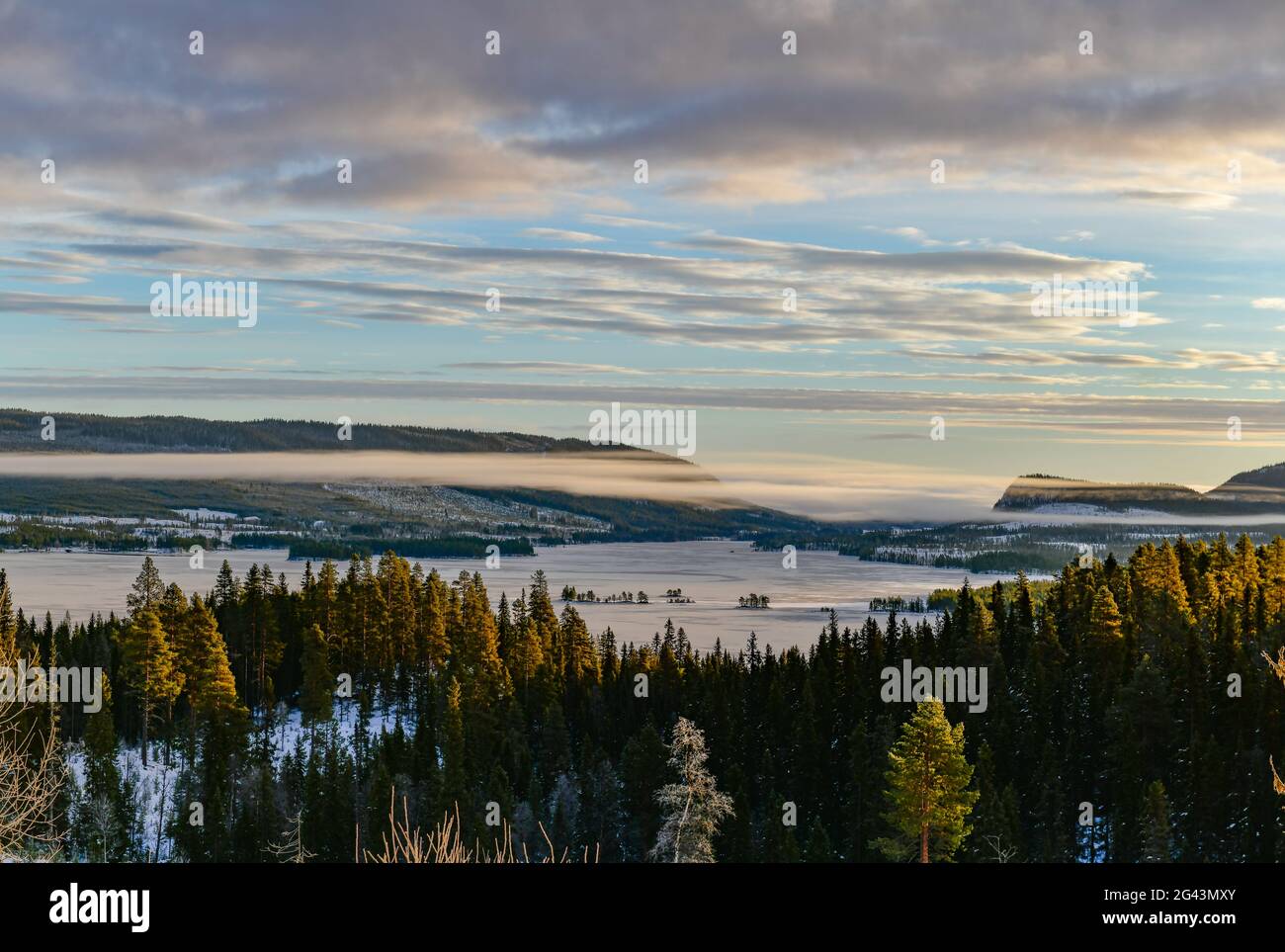 View over mountains and a valley with fog in winter, Asele, Lapland ...