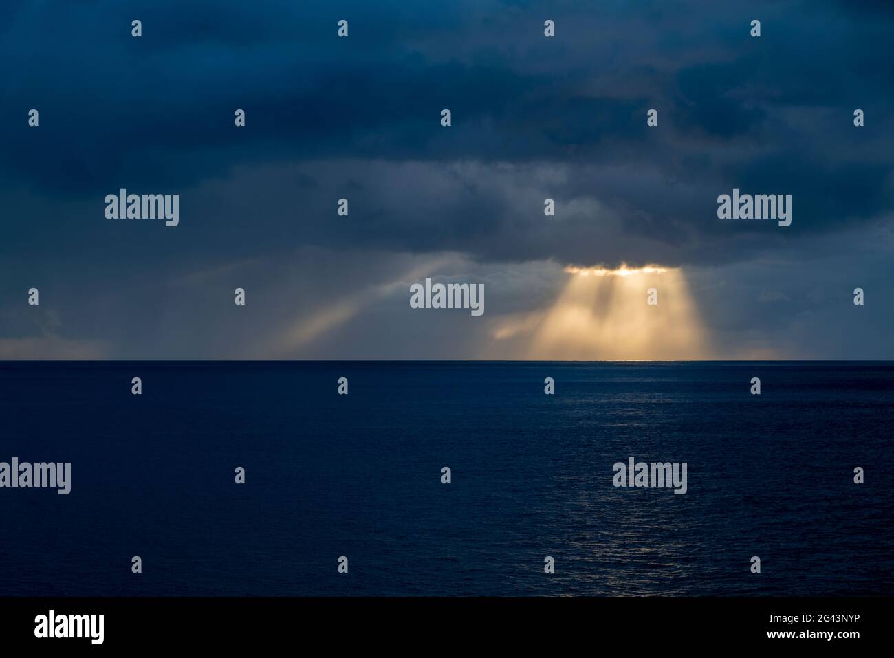 Sun rays break through storm clouds near Fatu Hiva, Marquesas Islands ...
