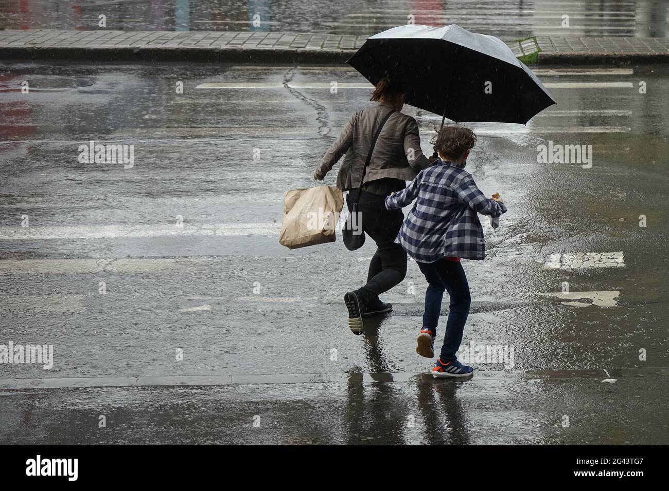 Bucharest, Romania - June 18, 2021: People cross the street on the run ...