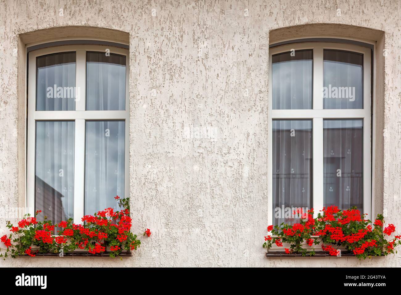 Windows with red flowers Stock Photo - Alamy