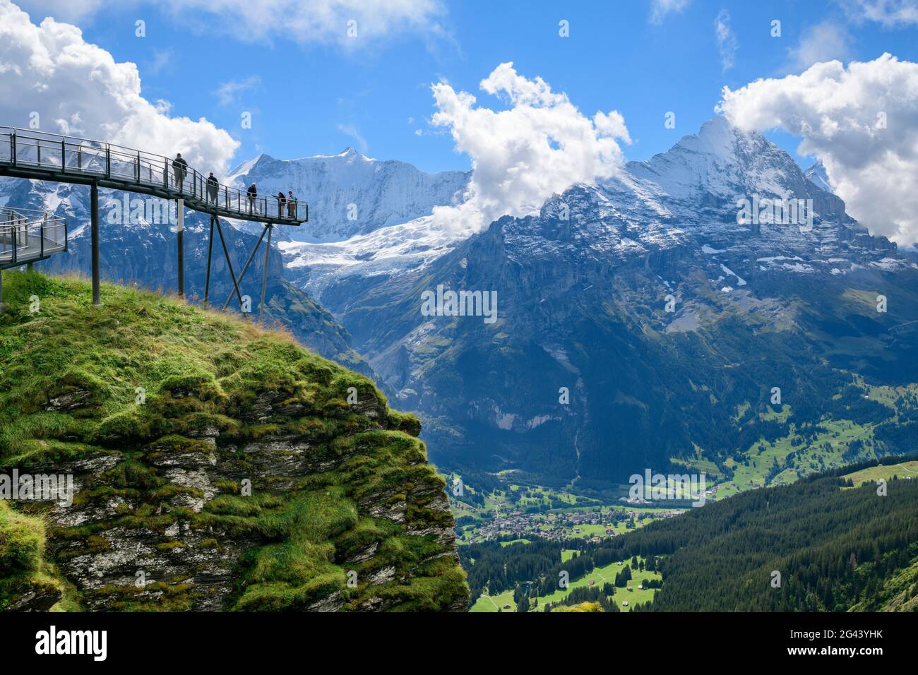 Several people stand on cliff walk with a view of Fiescherhorn and ...