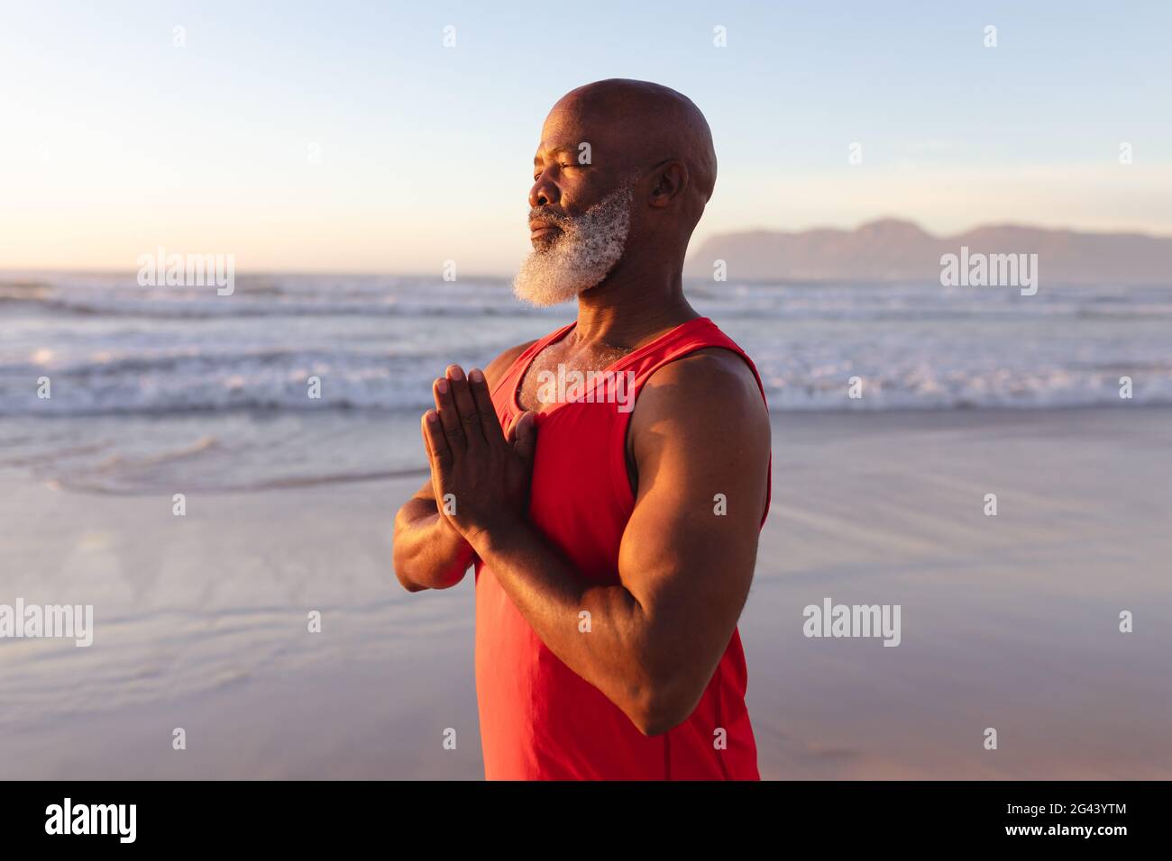 Senior african american man with folded hands meditating and practicing ...